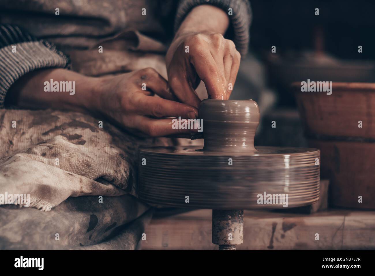 Modeling bowl from clay on wheel in pottery workshop. Dirty hands of ...