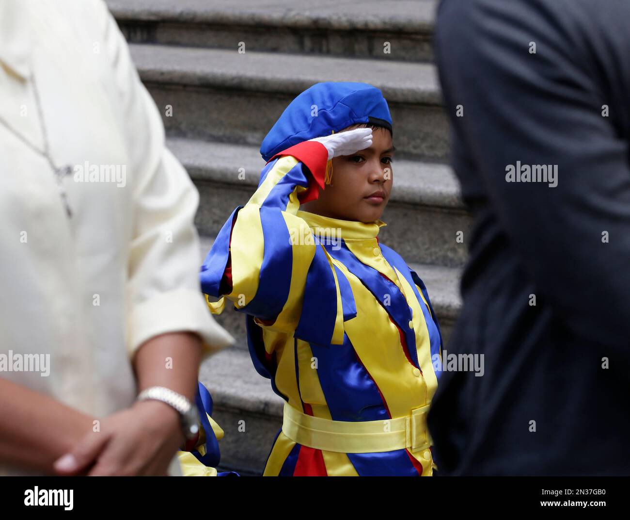 A boy, who is dressed as a Vatican Swiss guard, salutes during ...
