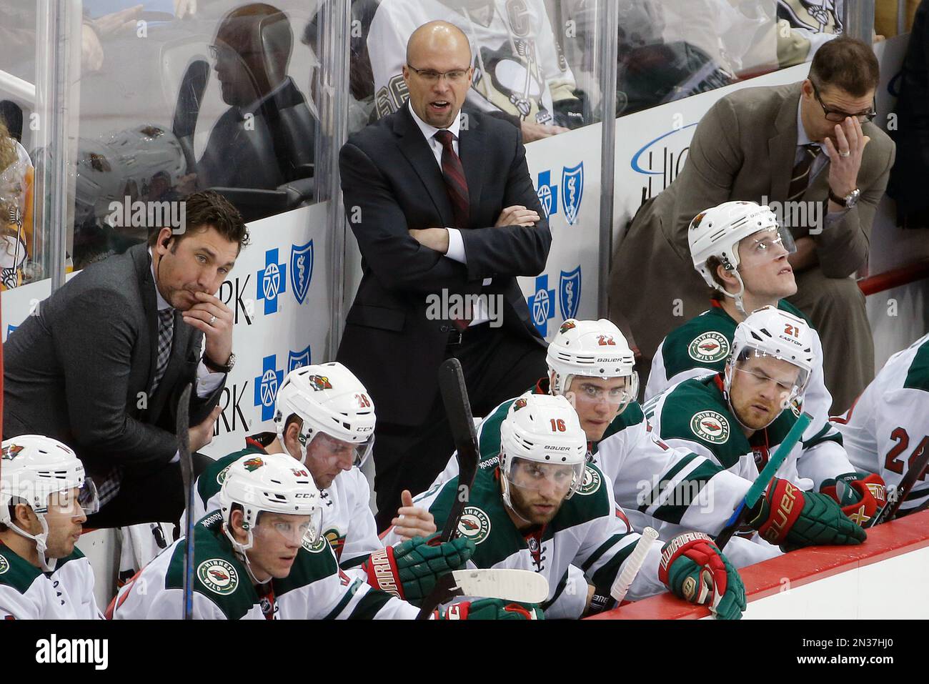 Minnesota Wild head coach Mike Yeo, center, is flanked by assistants ...