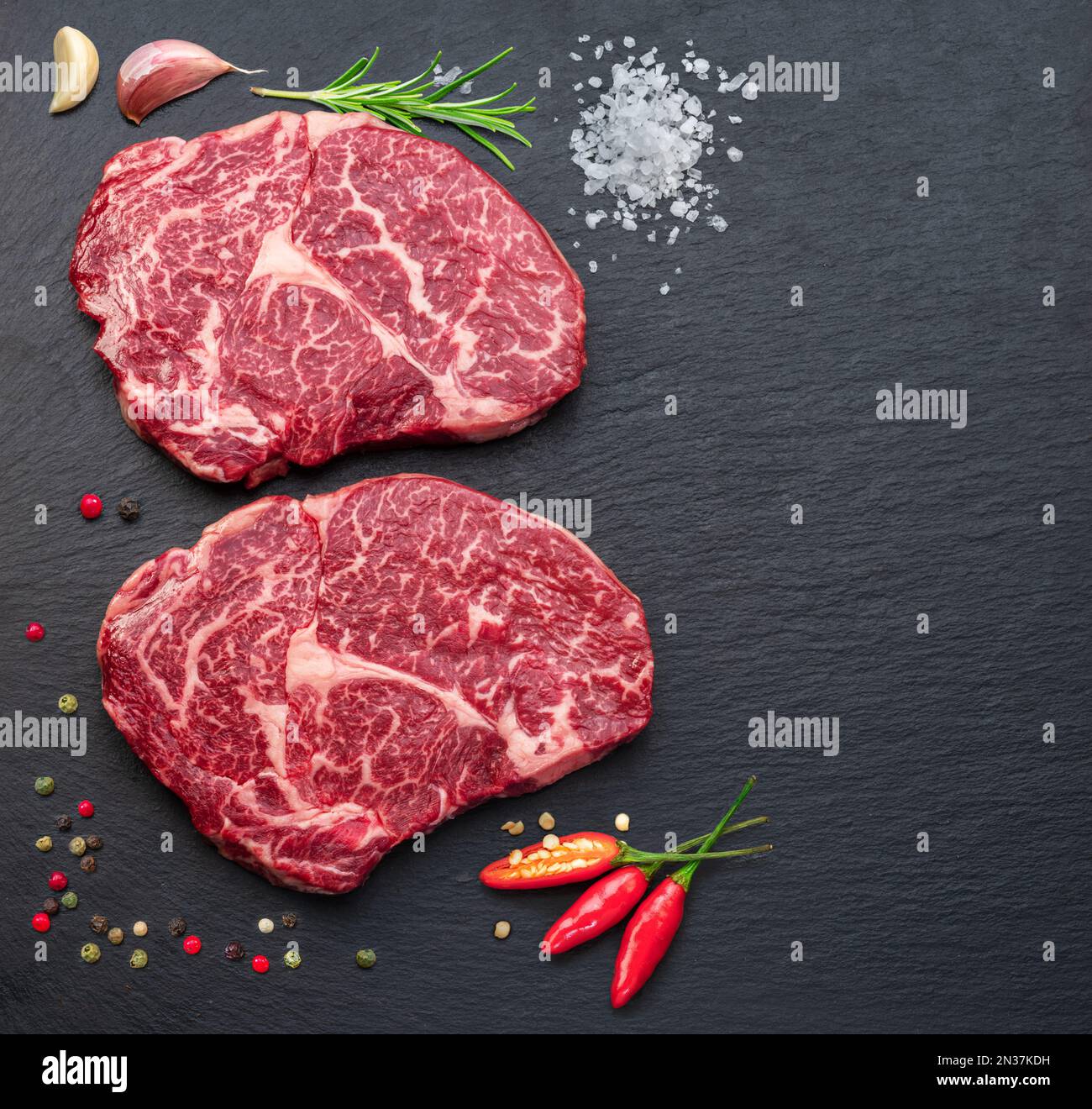 Raw ribeye steak on stone black serving plate. Flat lay Stock Photo - Alamy