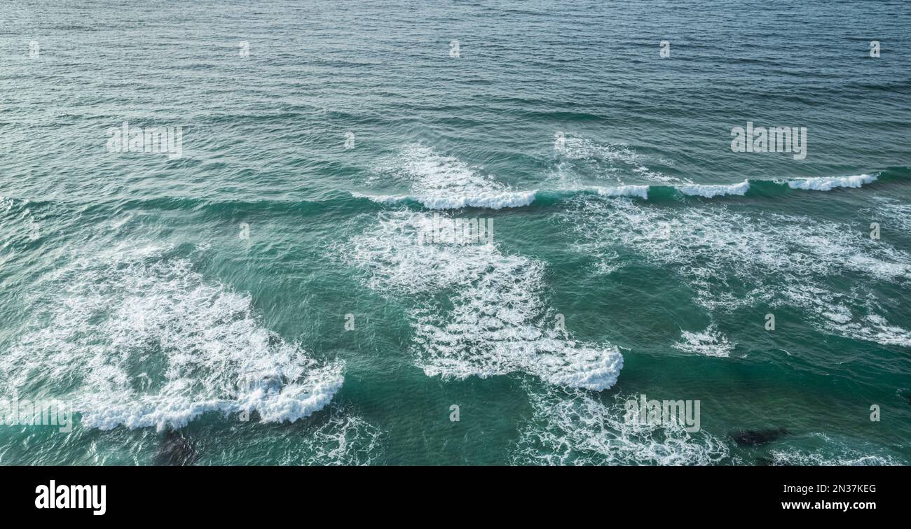 Ocean foamy waves approaching rocky shore. Top view Stock Photo - Alamy