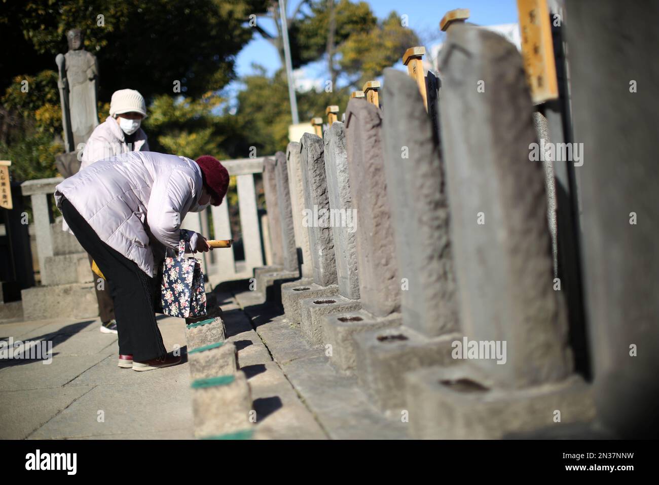 In this Jan. 8, 2015 photo, people offer joss ticks to the graves of ...