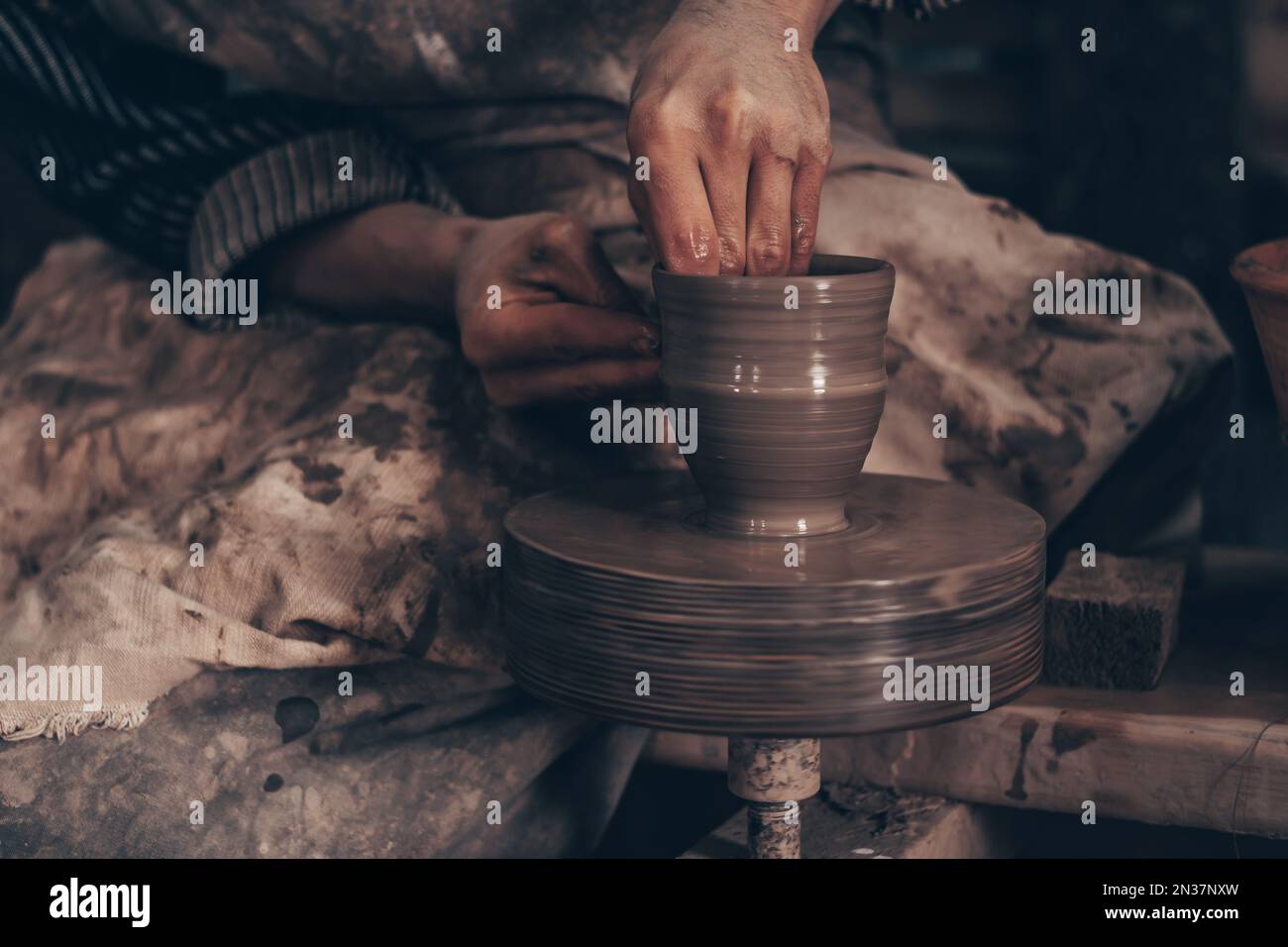 Modeling bowl from clay on wheel in pottery workshop. Hands of ...