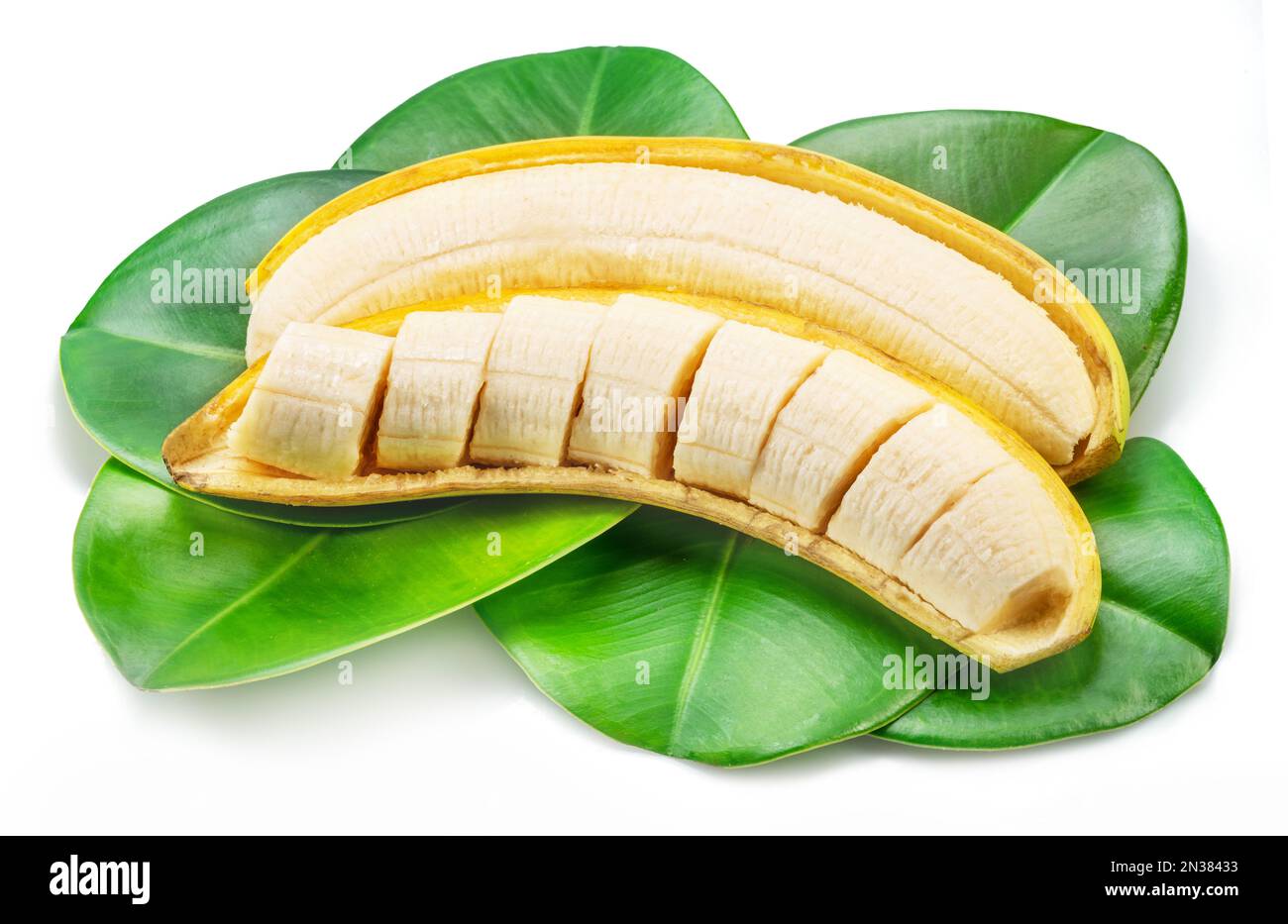 Banana cuts in banana peel over green banana leaves isolated on white ...