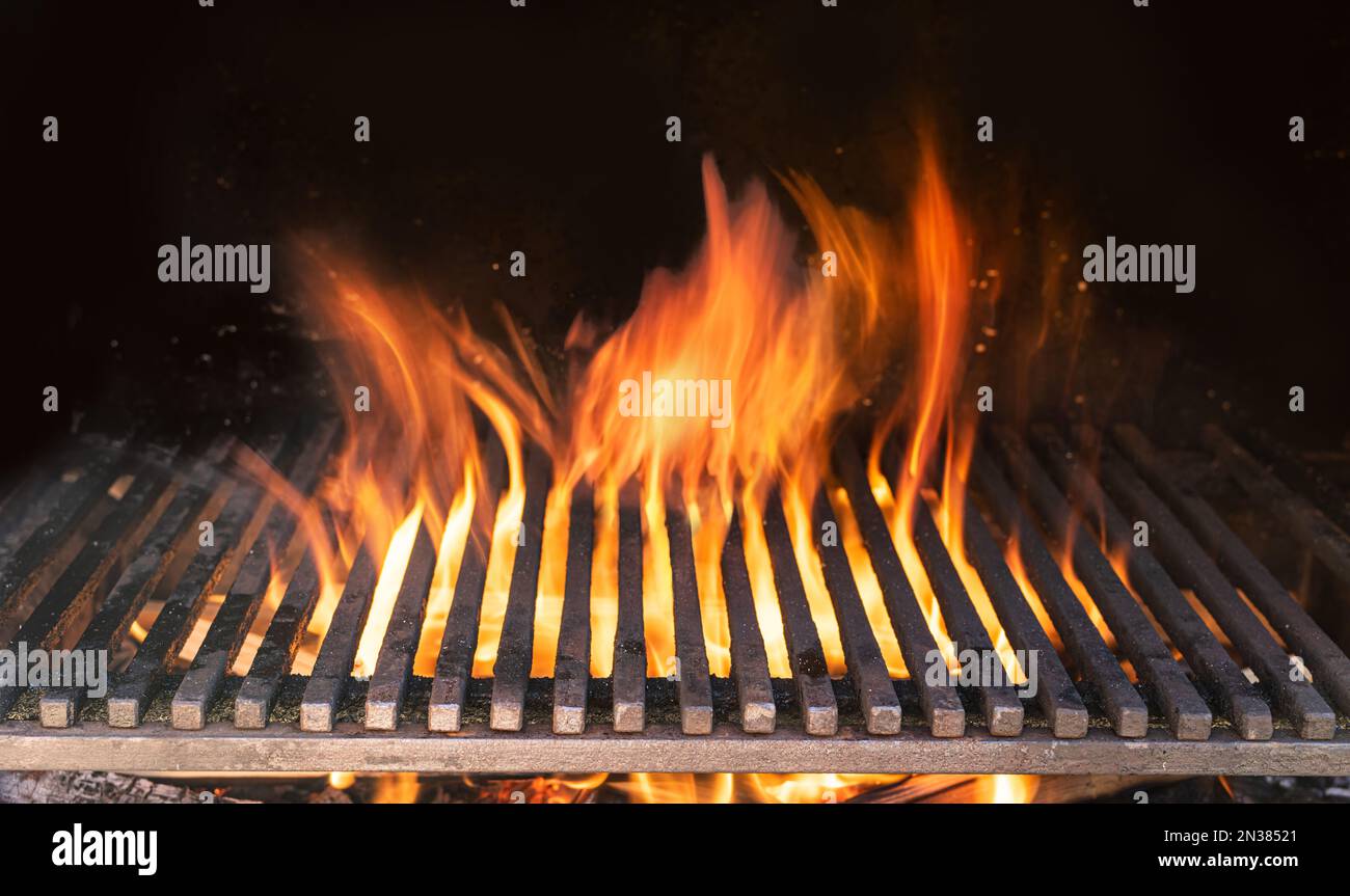 Barbecue grill with fire flames closeup on dark background Stock Photo ...