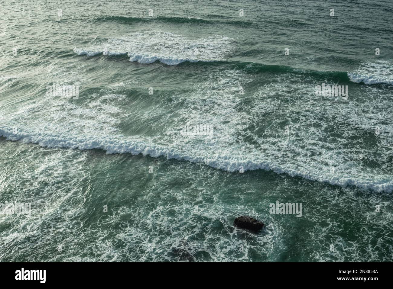 Ocean foamy waves approaching rocky shore. Top view Stock Photo - Alamy