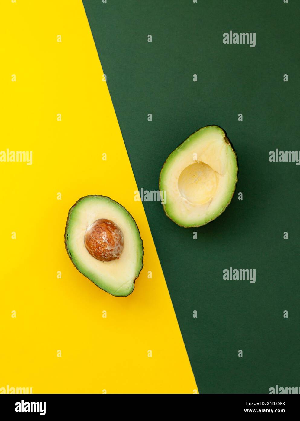 avocado with seed, avocado halves and whole fruits on yellow and green ...