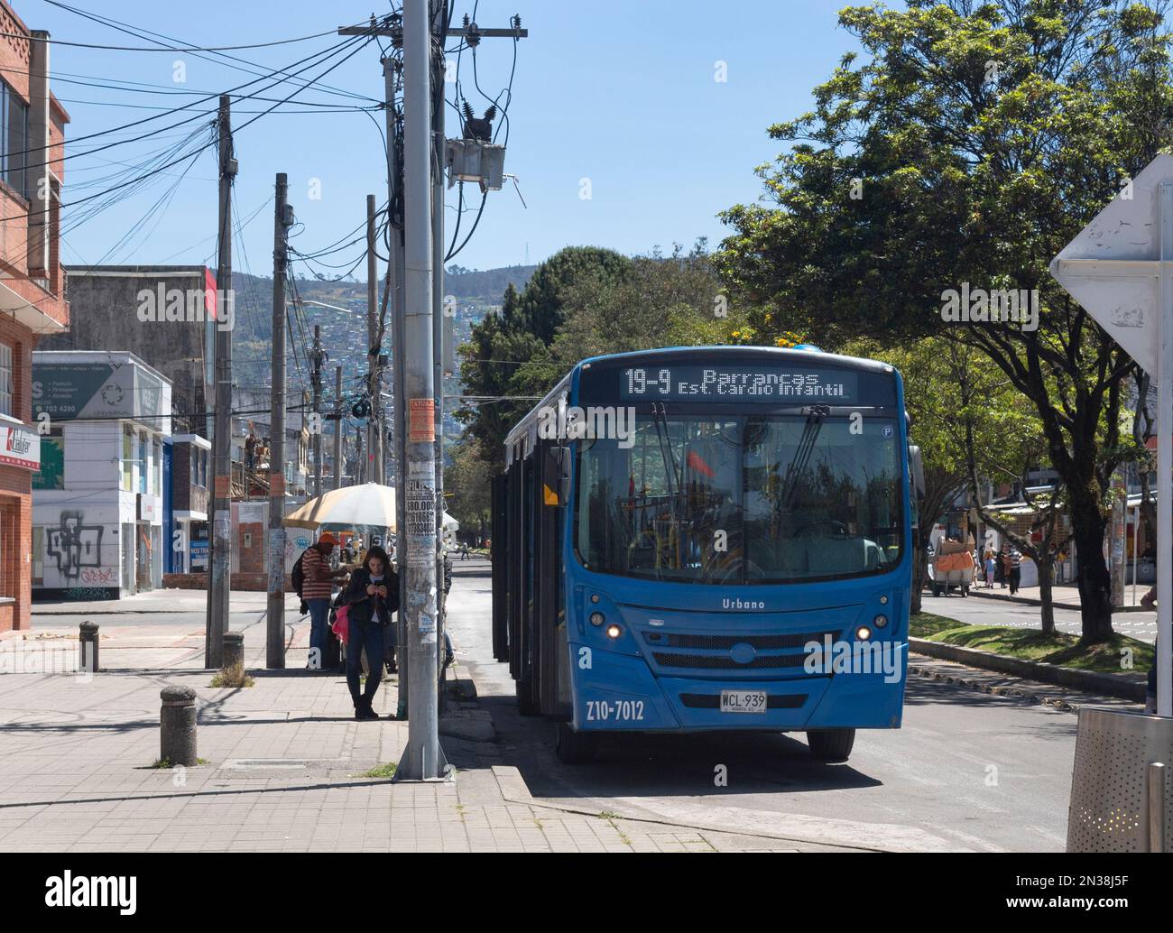 BOGOTA, COLOMBIA - A relaxing woman awaits near to a big SITP blue bus ...