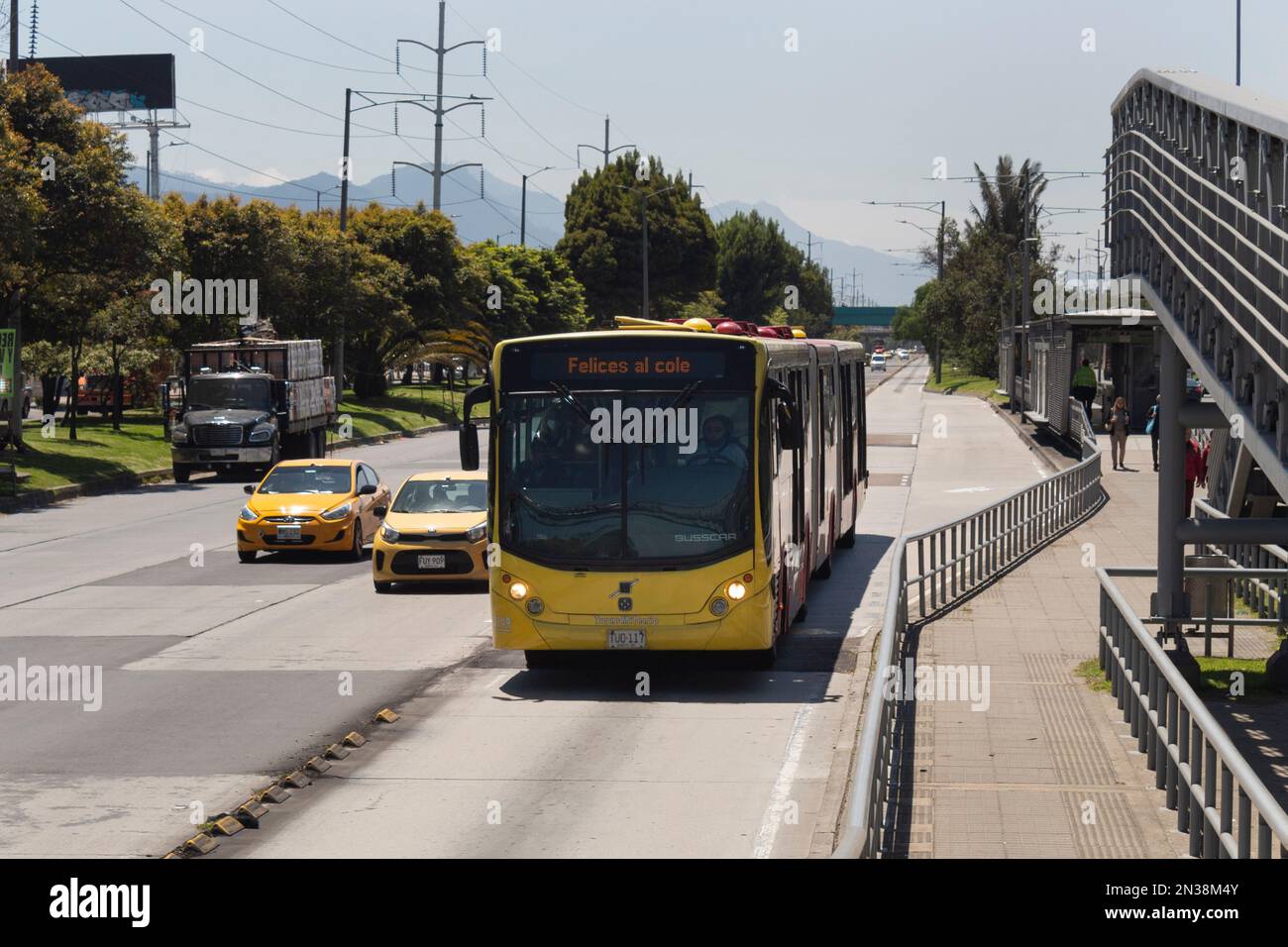 BOGOTA, COLOMBIA - A Transmilenio yellow bus with two taxis transiting ...