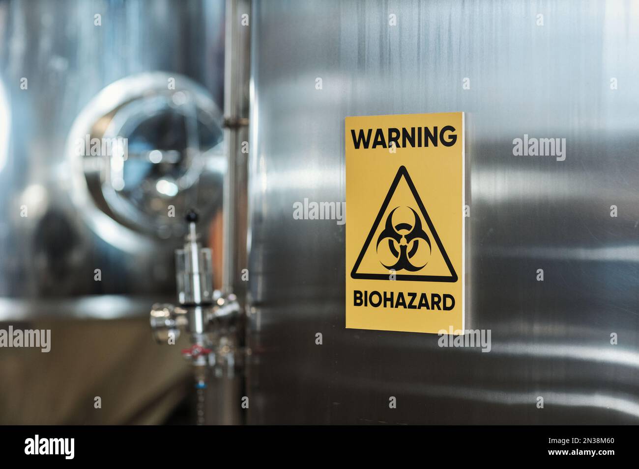 Close up of Warning biohazard sign on storage tank in chemical factory ...