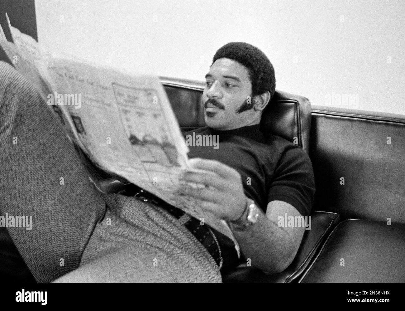 Defensive tackle Jethro Pugh of the Dallas Cowboys, relaxes and reads a ...