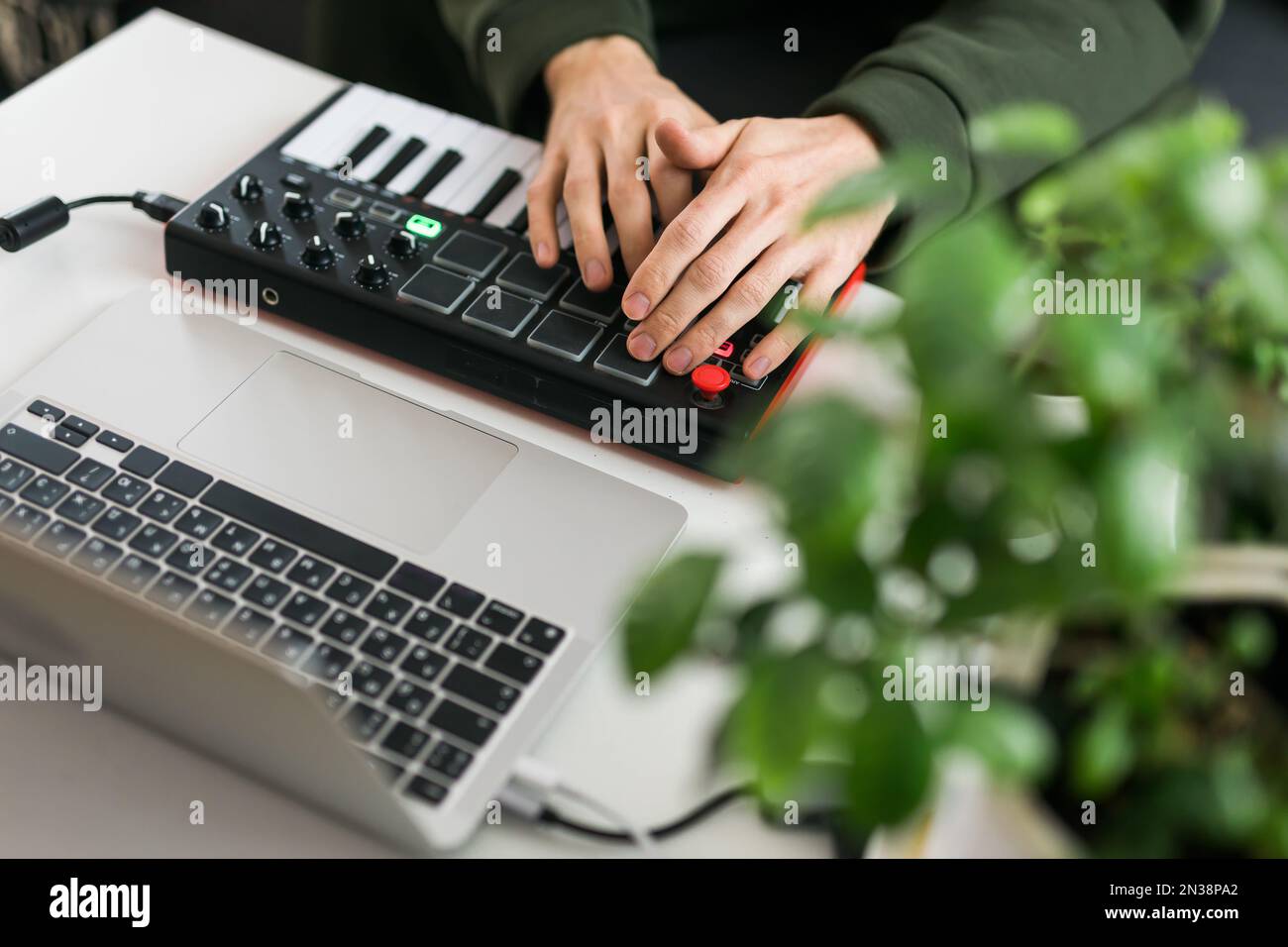 Top view of music producer or arranger using laptop and midi keyboard ...