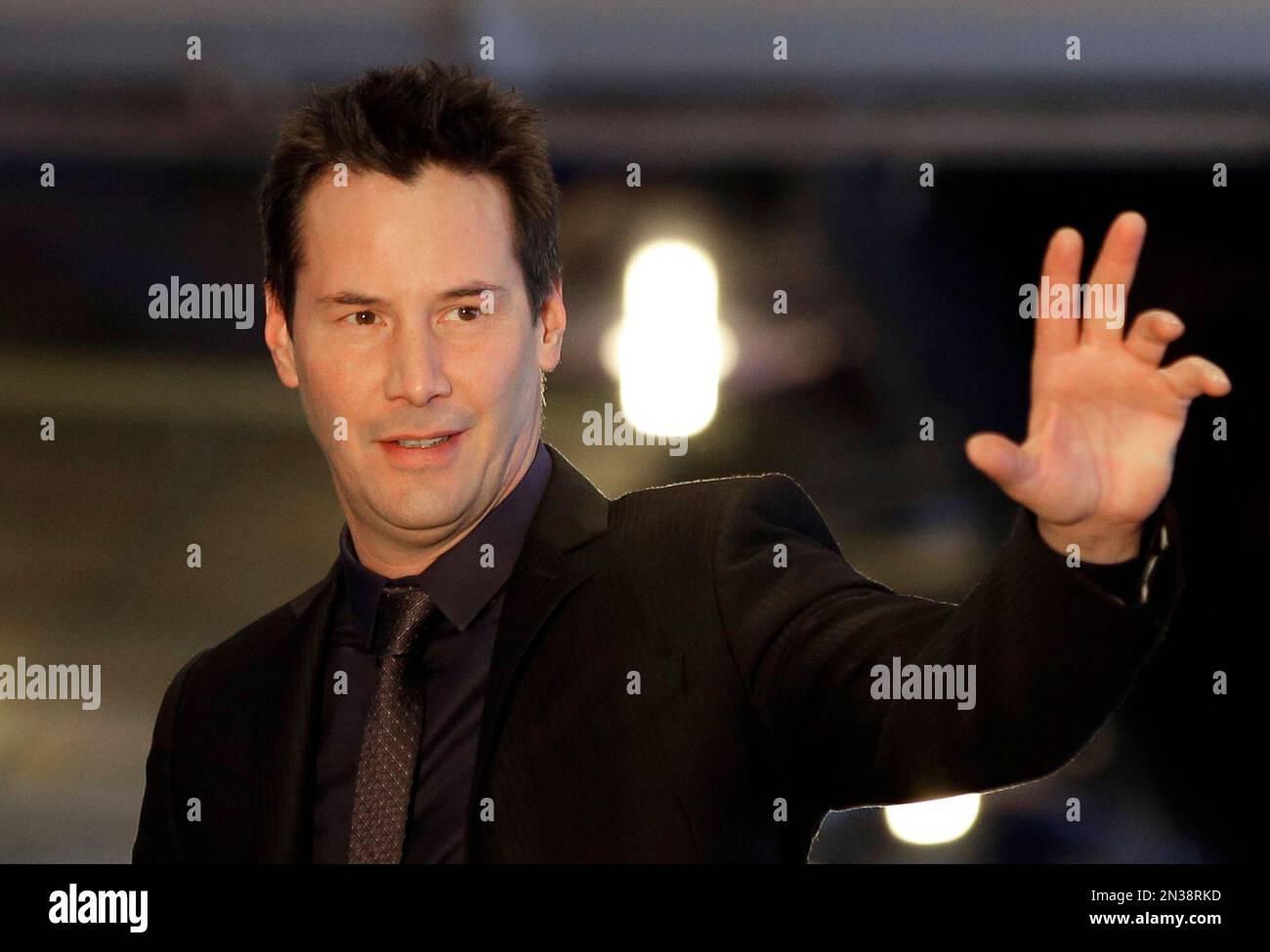 Actor Keanu Reeves waves to his fans during the red carpet event for ...