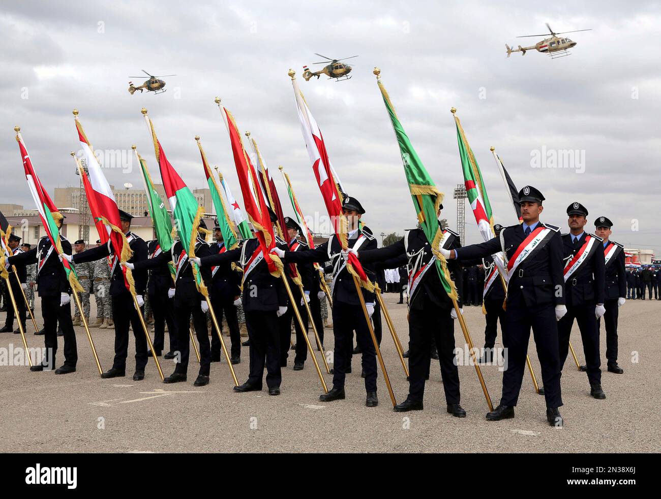 Iraqi policemen hold national flags during a ceremony marking Police ...