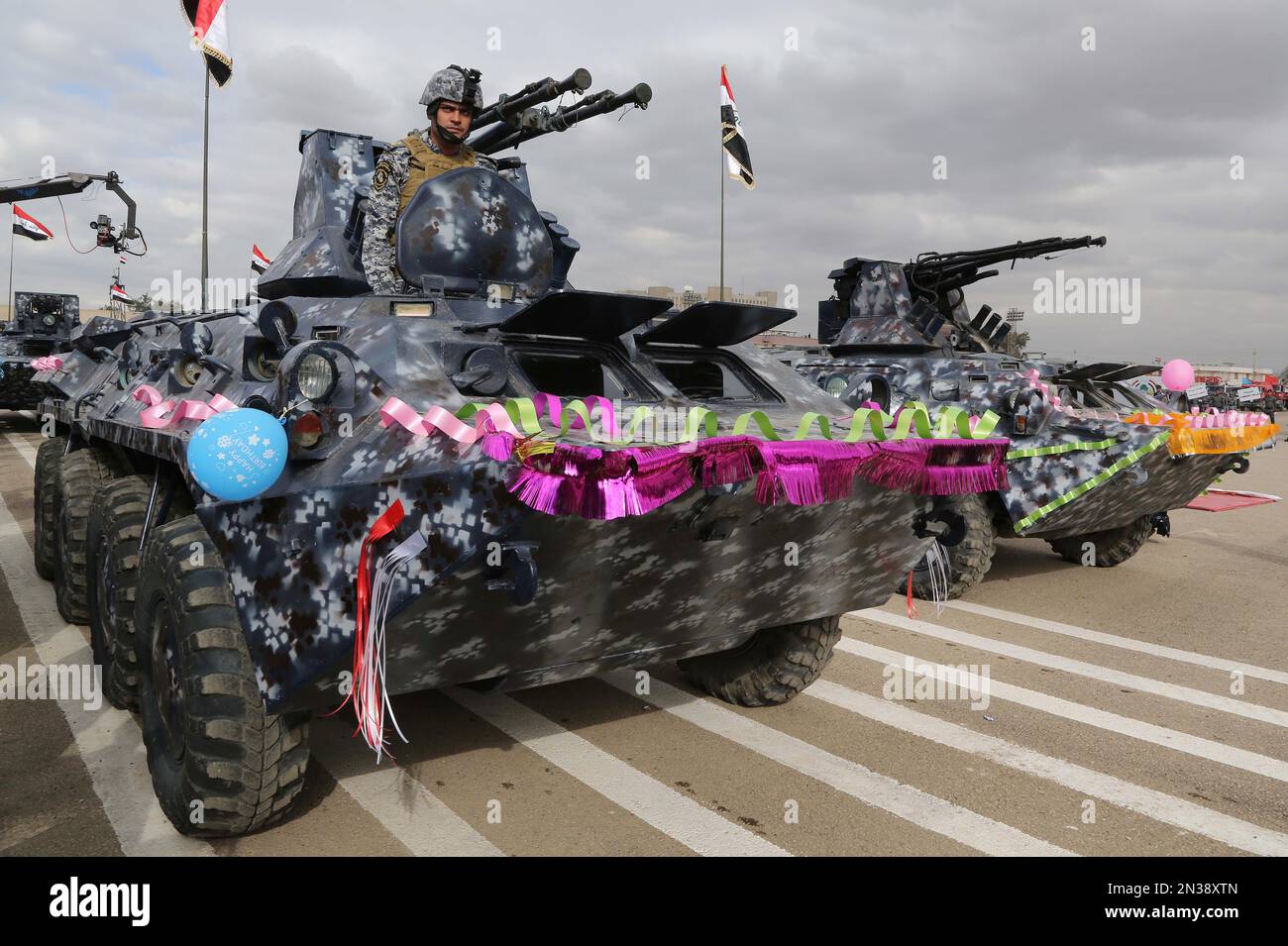 An Iraqi policeman rides an armored vehicle in a parade marking Police ...