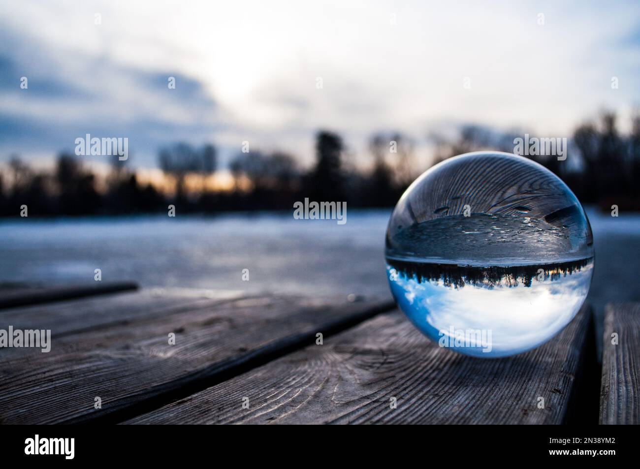 A transparent ball with nature reflections on a park bench Stock Photo ...