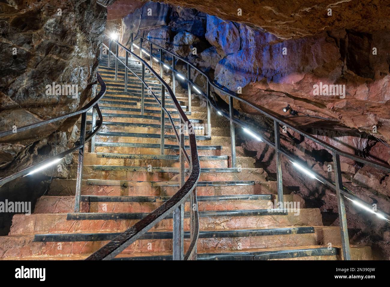 An illuminated staircase inside Goughs Cave in Cheddar in Somerset ...