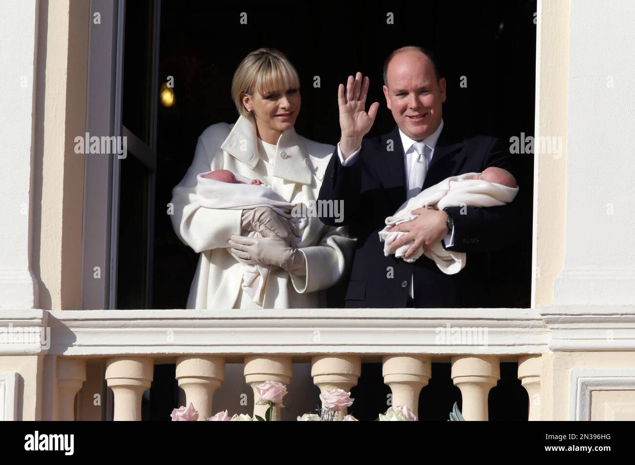 Princess Charlene and Prince Albert appear on a palace balcony, each ...