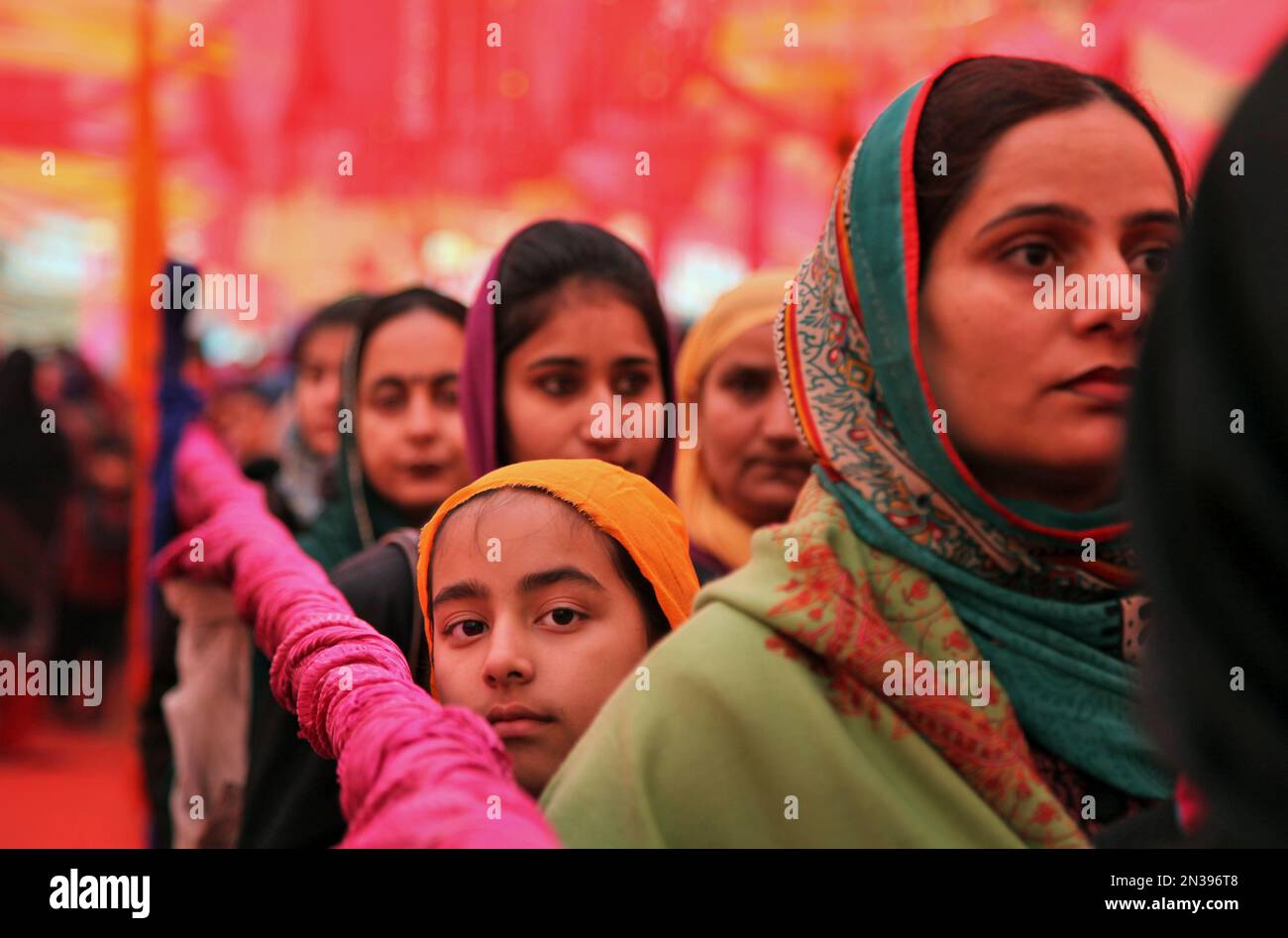 Sikh devotees stand in a queue to offer prayers at a gurudwara, or Sikh ...