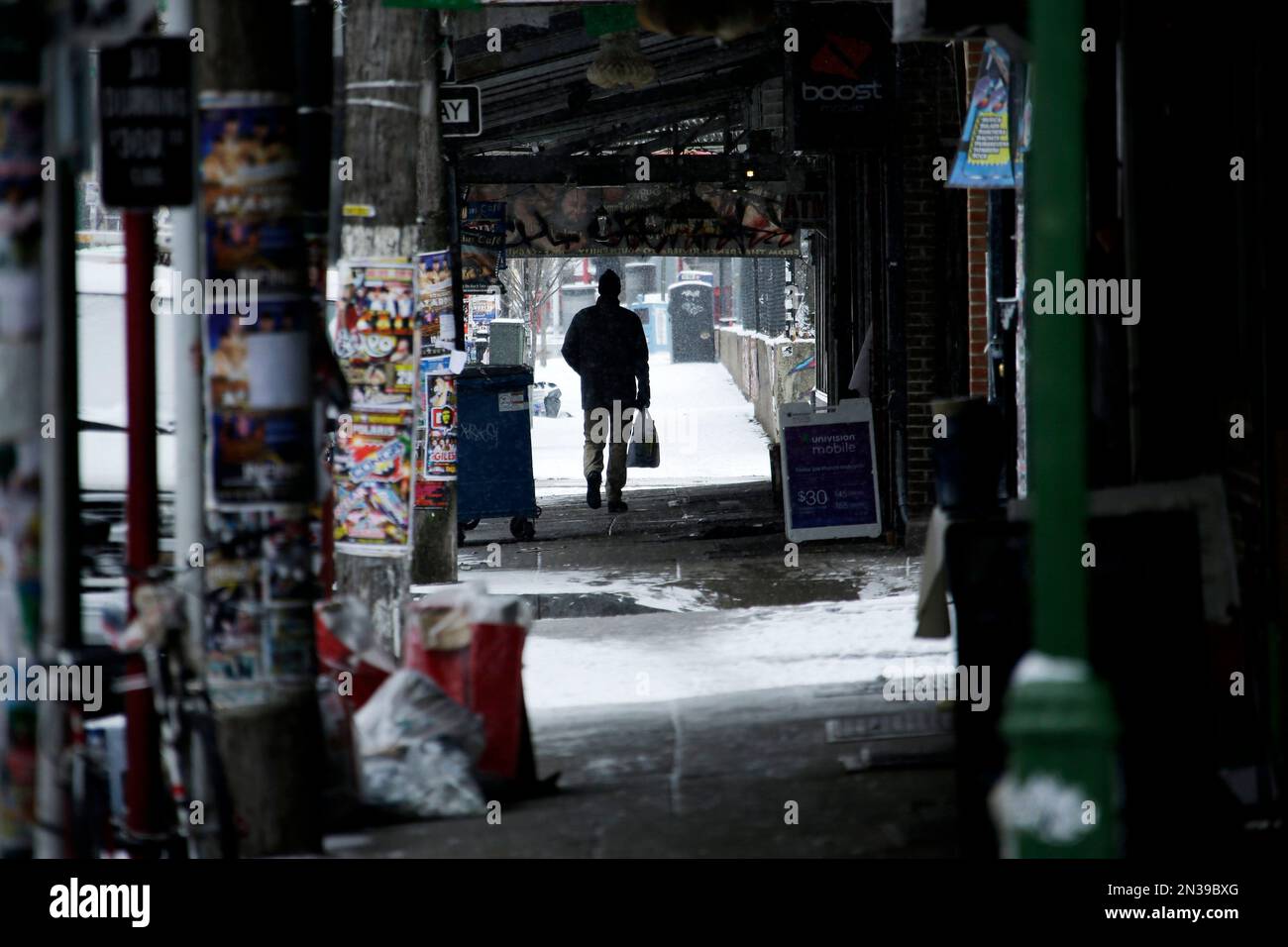 A man walks through the Italian Market during a winter storm, Tuesday ...