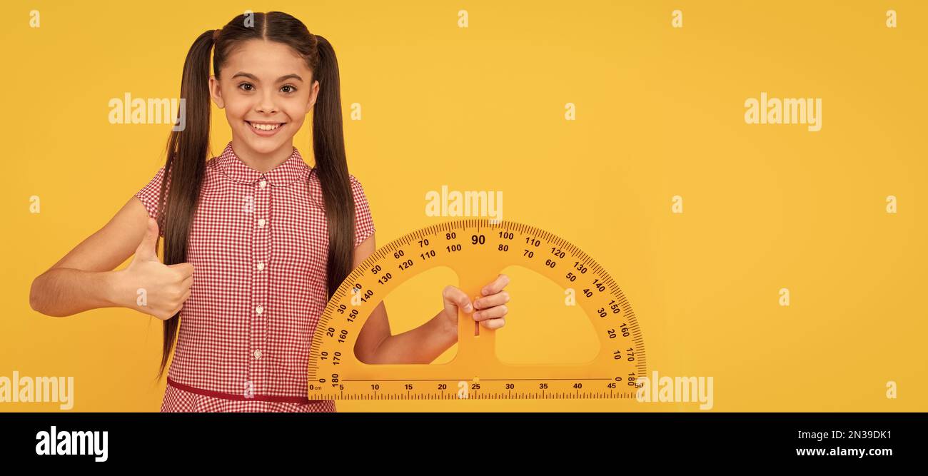 happy child hold school math tool protractor ruler on yellow background ...