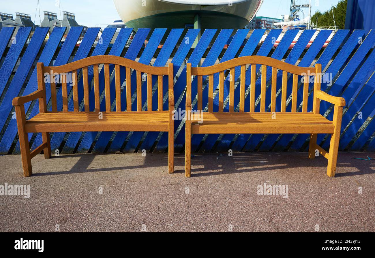 Two wooden benches in front of a blue picket fence Stock Photo - Alamy