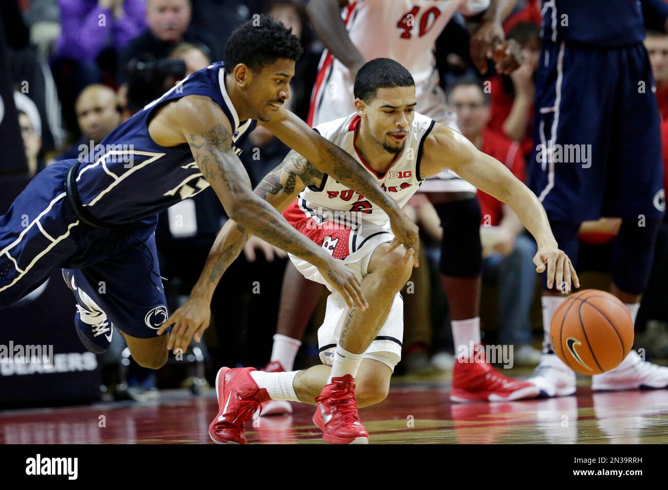 Rutgers' Bishop Daniels (2) and Penn State's Geno Thorpe (13) grab for ...