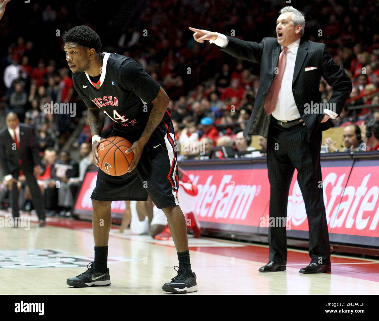 Fresno State's Julien Lewis tries to run a play while New Mexico head ...