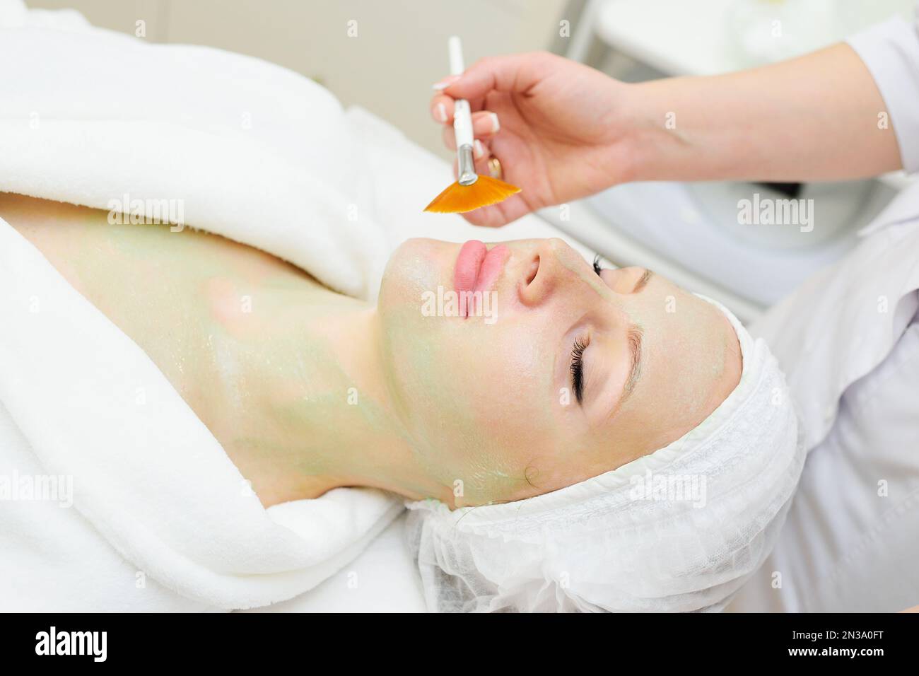 A cosmetologist performs an enzyme therapy procedure for a female ...