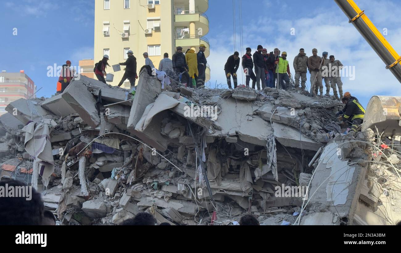 People and emergency teams search for survivors in the rubble of a ...
