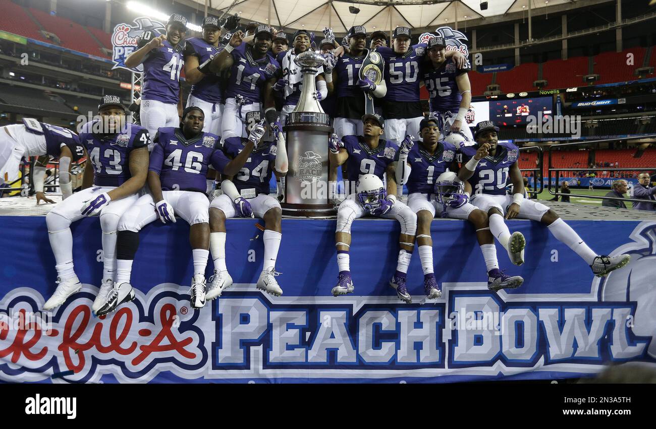 TCU players pose for a photo with the Peach Bowl trophy after the ...