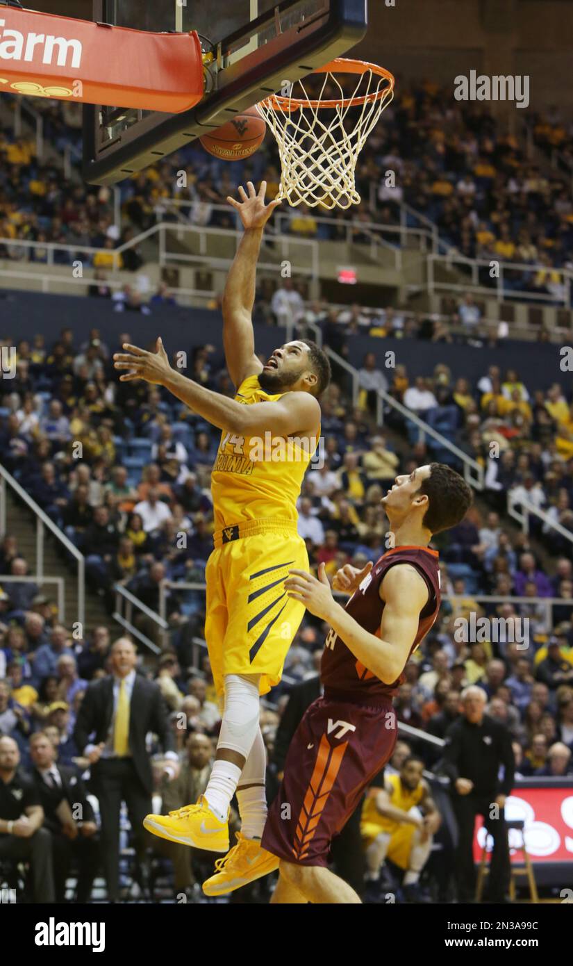 West Virginia guard Gary Browne (14) scores as Virginia Tech guard ...