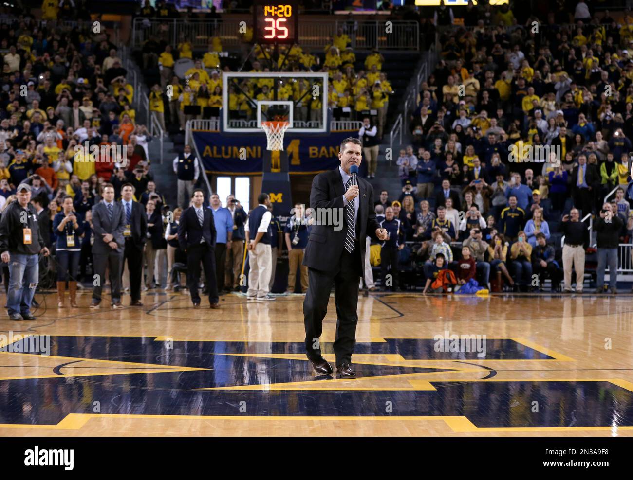 Michigan football coach Jim Harbaugh greets fans during halftime of an ...