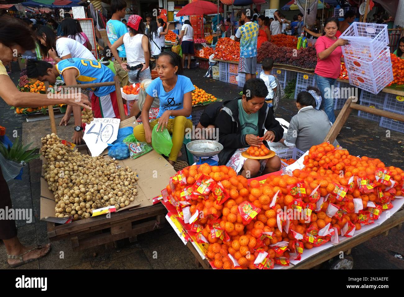 Filipino vendors arrange round fruits at their makeshift stores in ...