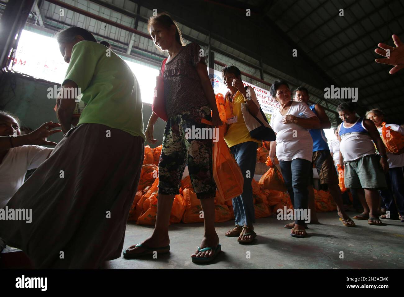 Filipino women line up during a Christmas season gift-giving to poor ...