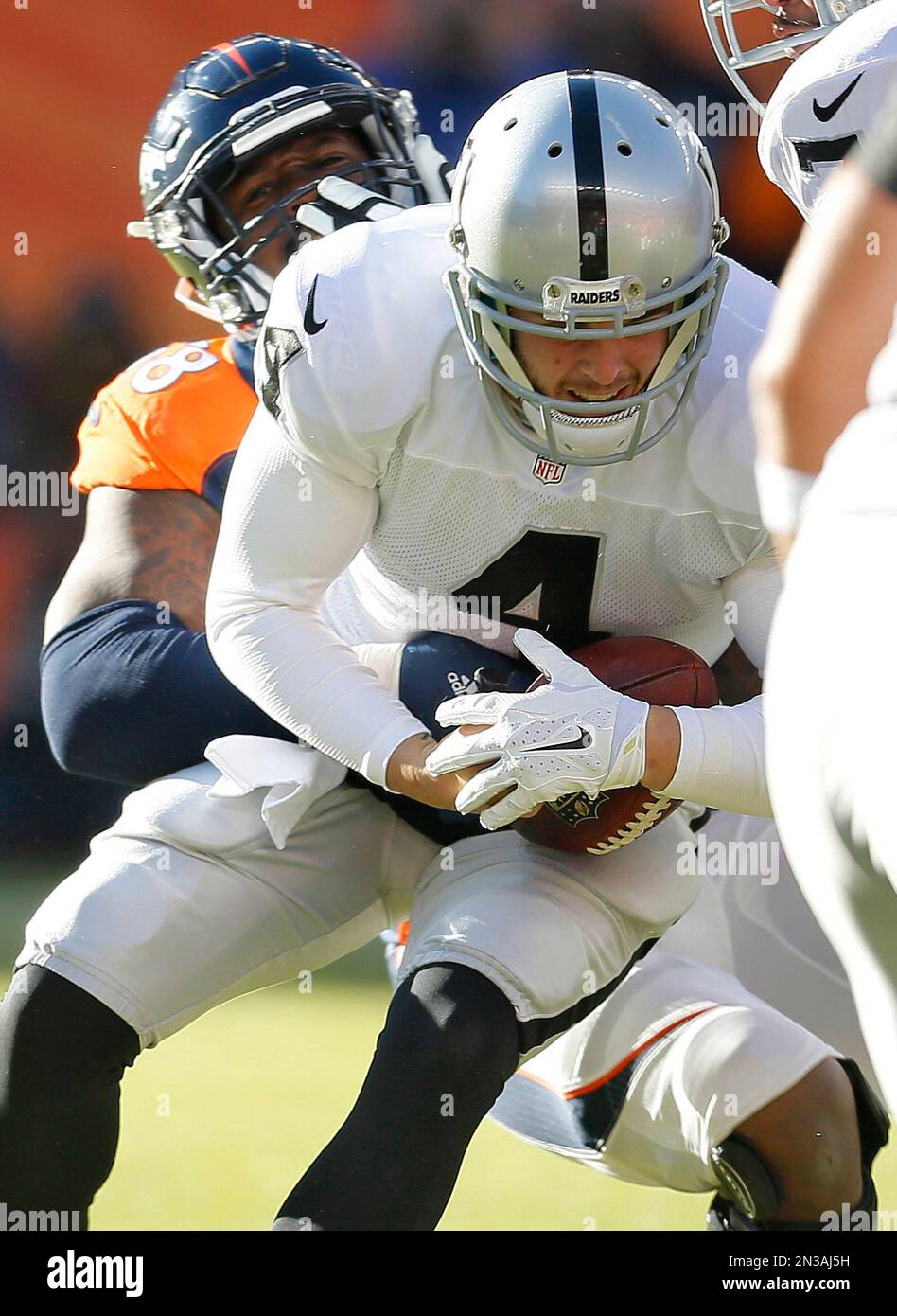 Oakland Raiders quarterback Derek Carr (4) is sacked by Denver Broncos ...