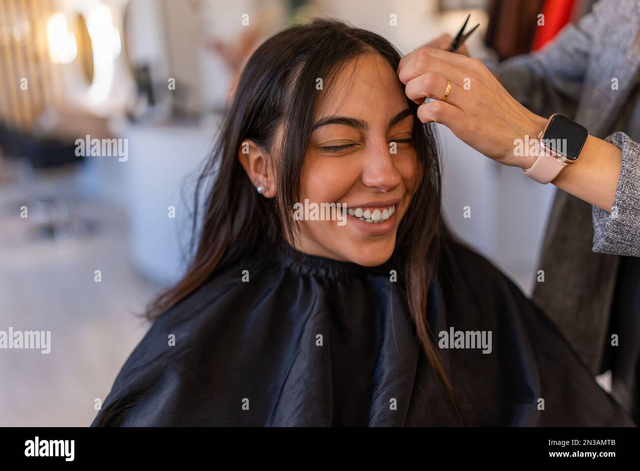 Positive young female client smiling and sitting with closed eyes while ...
