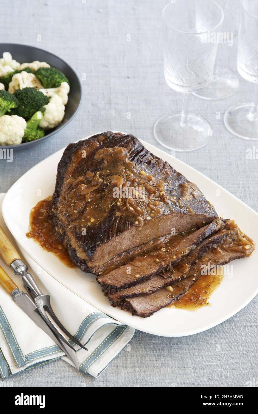 Beef brisket on platter with a side dish of cauliflower and broccoli ...