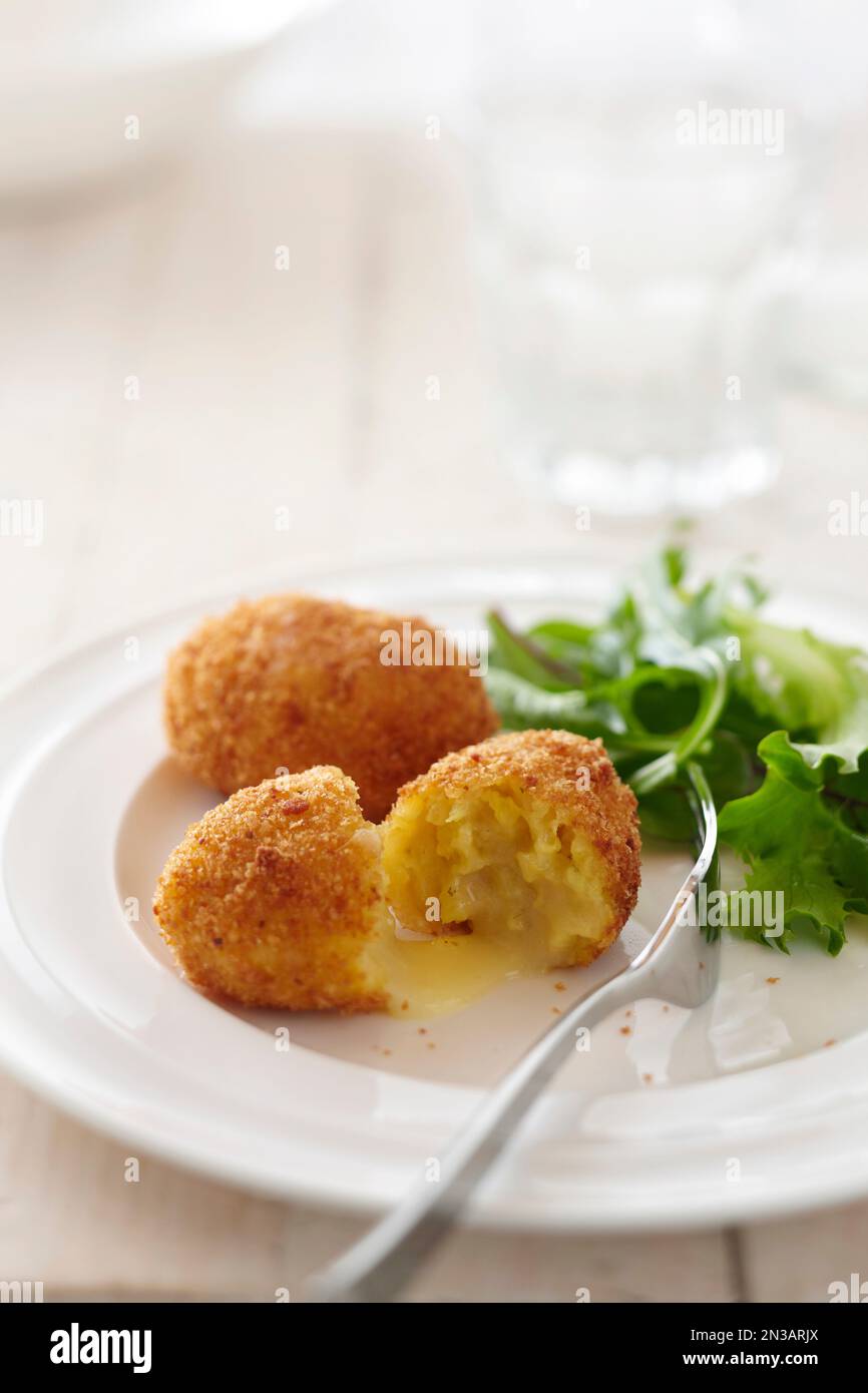 Risotto rice balls with cheese filling and a side salad Stock Photo - Alamy