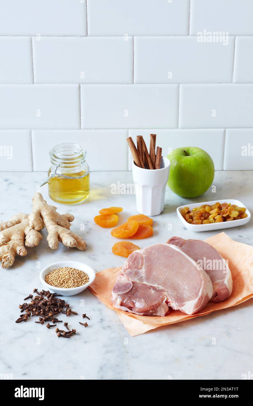 Pork chop dinner ingredients on a marble countertop with white tiled ...