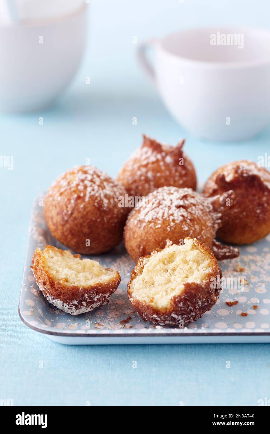 Mini cake donuts with powdered sugar on a blue platter Stock Photo - Alamy