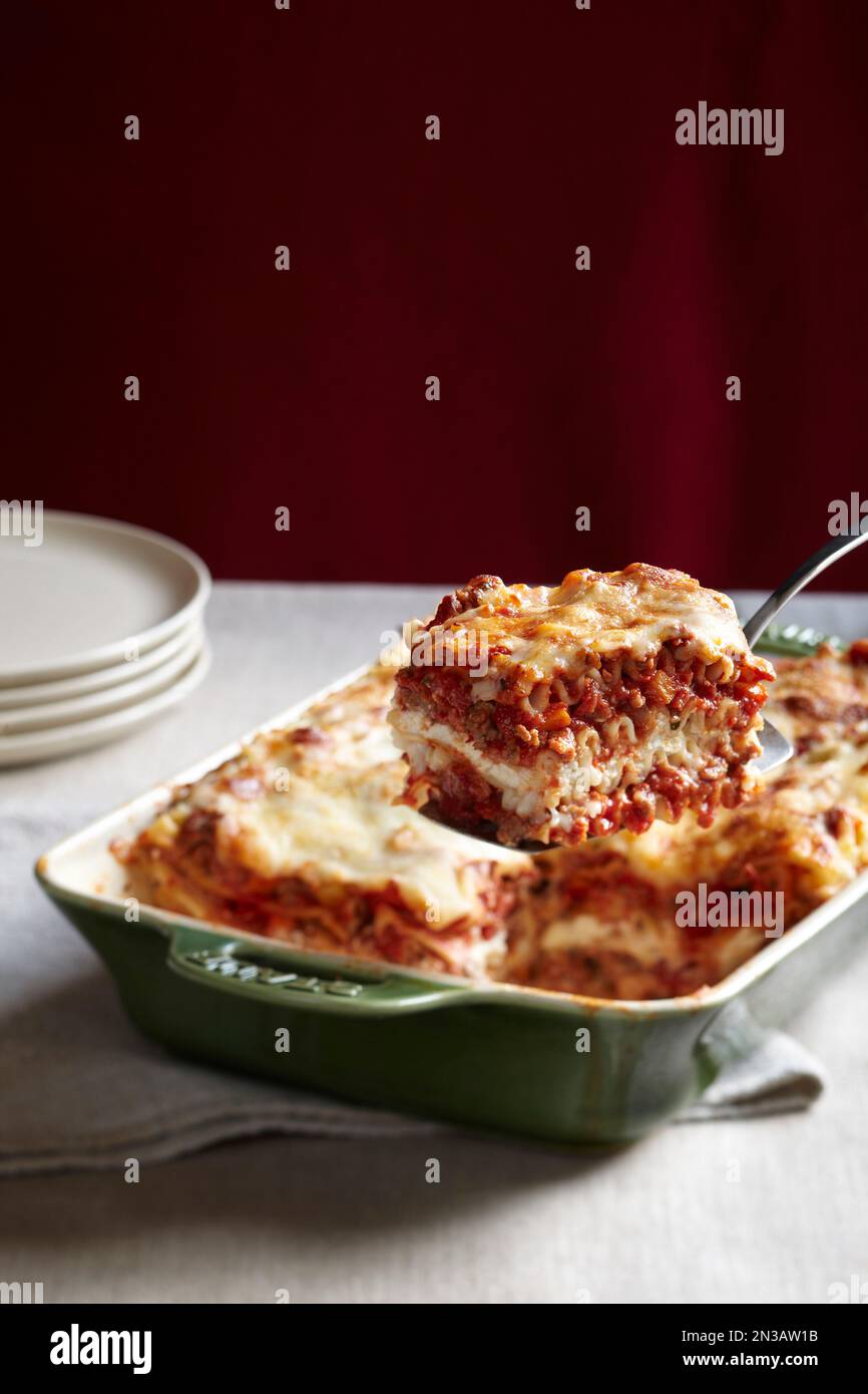 Slice of lasagna on a spatula being lifed out of a pan Stock Photo - Alamy