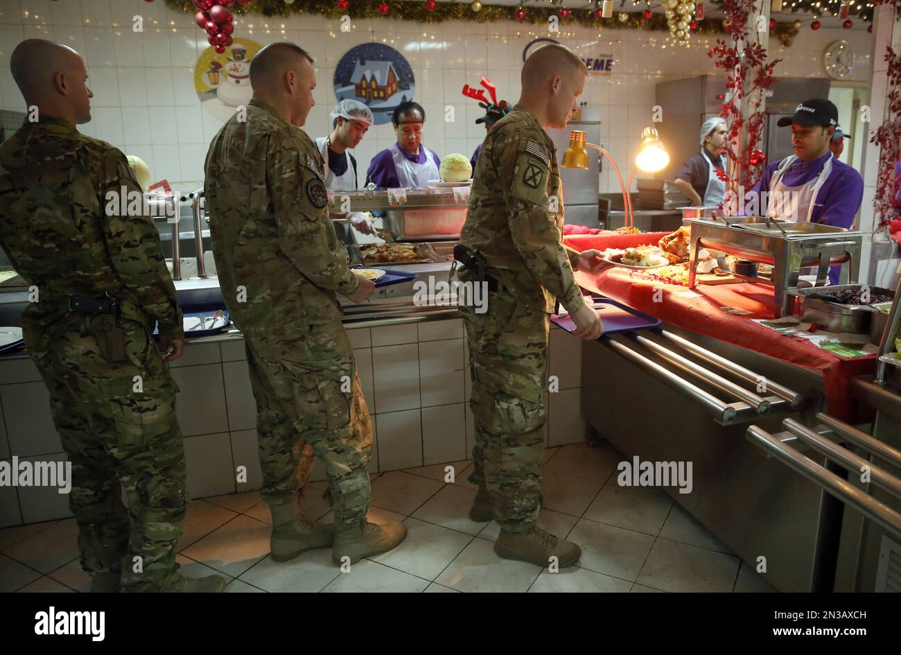 NATO service members line up to pick their meal during Christmas ...