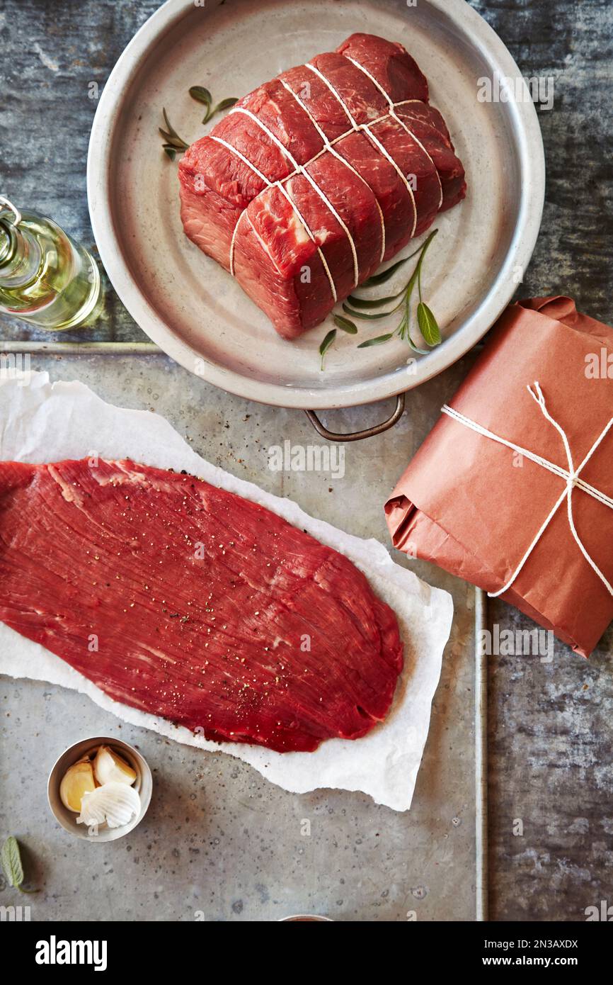 Still life of beef with butcher paper on a metal background Stock Photo ...