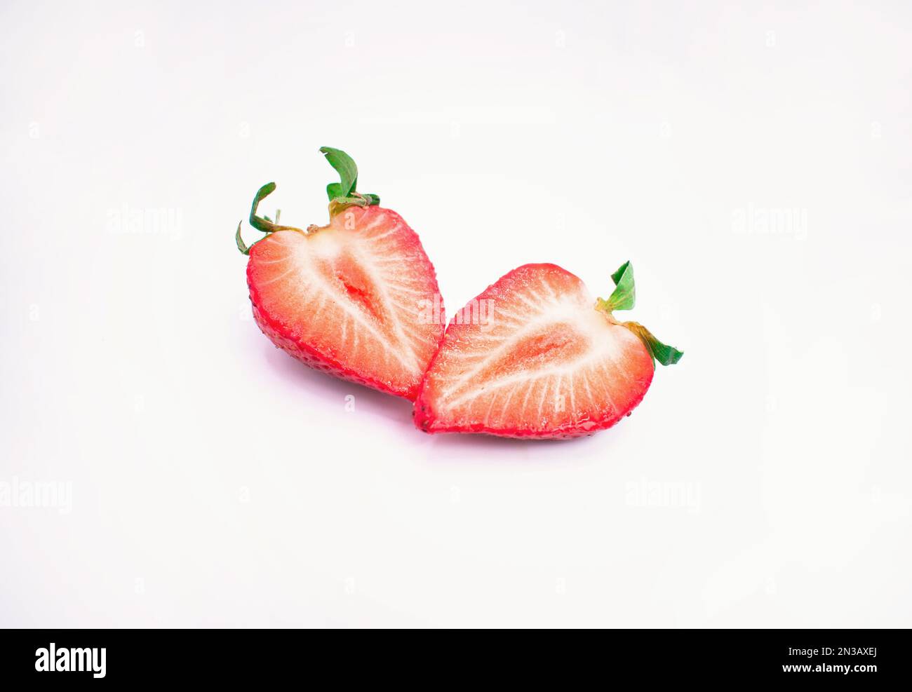 A juicy fresh halved strawberry isolated on a white background Stock ...