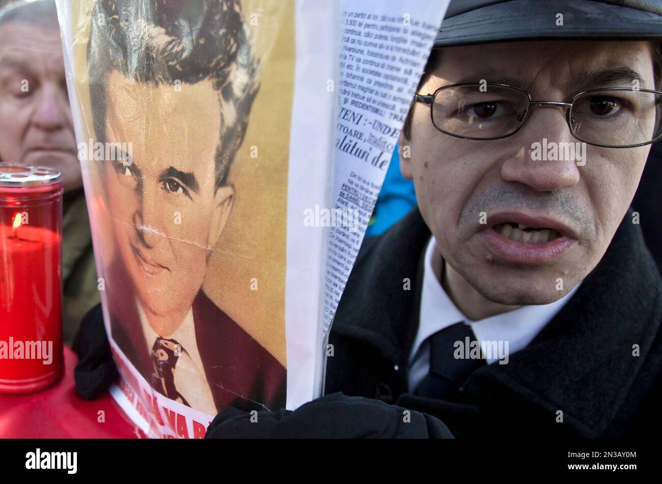 A man speaks holding a picture of Romanian communist dictator Nicolae ...