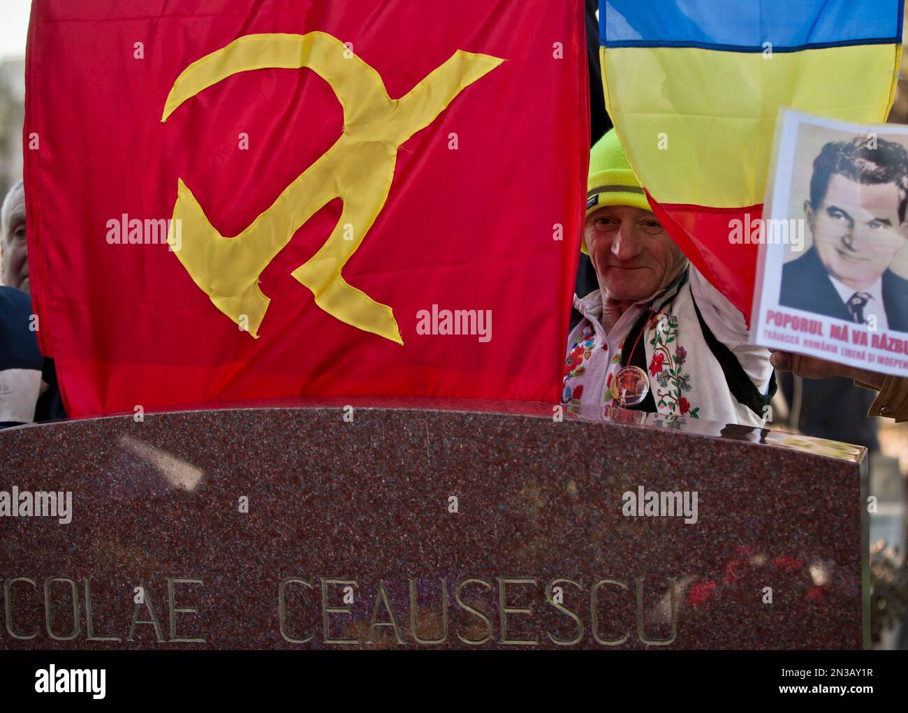 A man stands behind the gravestone of Romanian communist dictator ...
