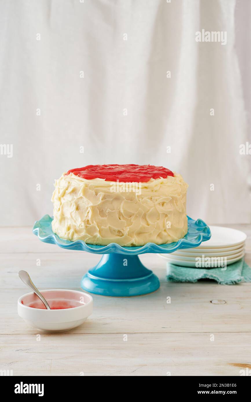 Vanilla rhubarb cake on a turquoise cake stand with white background ...