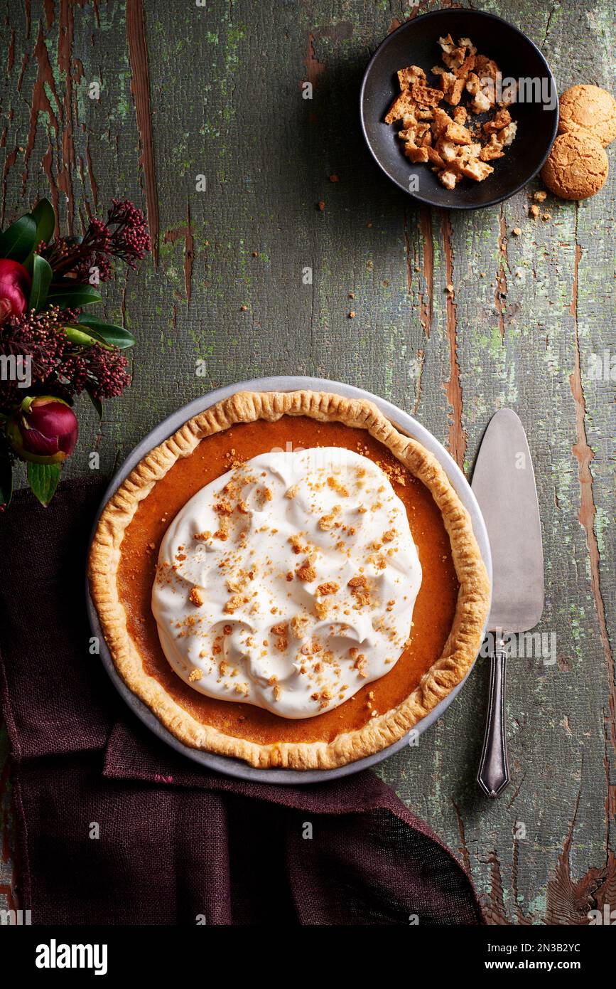 Pumpkin cheesecake pie and pie server on a grey, wooden background ...