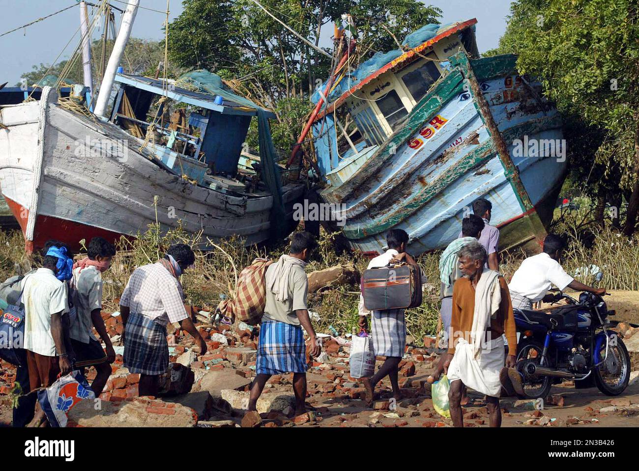 FILE - In this Dec. 28, 2004 file photo, villagers walk with their ...